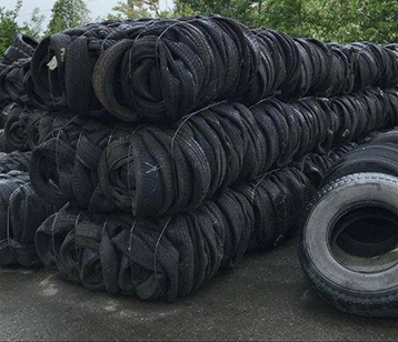 Stacks of compressed, bundled used tires, processed by a tyre baler ...